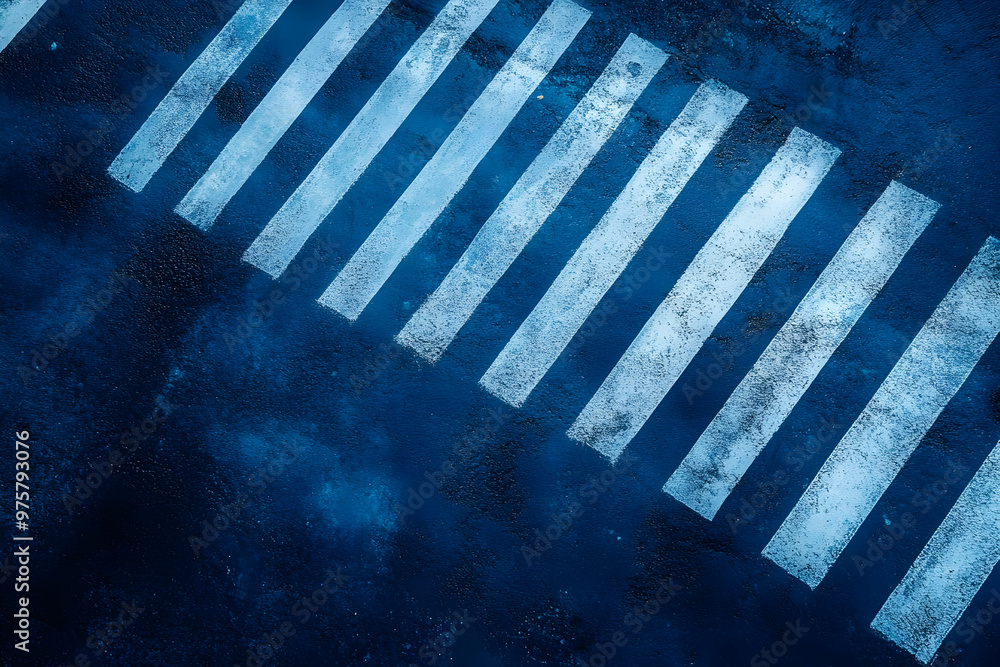 Aerial view of a faded pedestrian crosswalk pattern on a dark textured ...