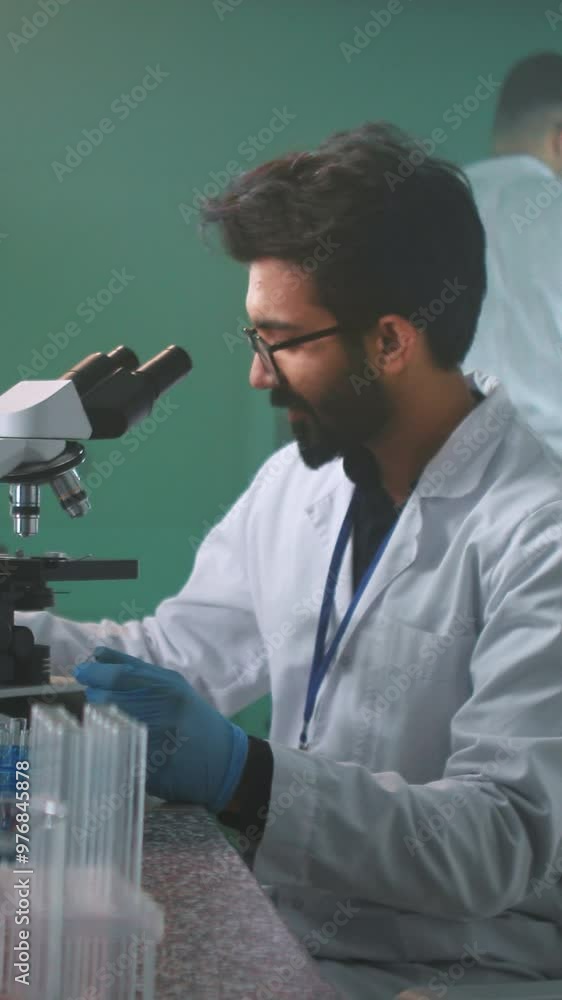 Slow motion young man scientist with glasses and protective gloves ...