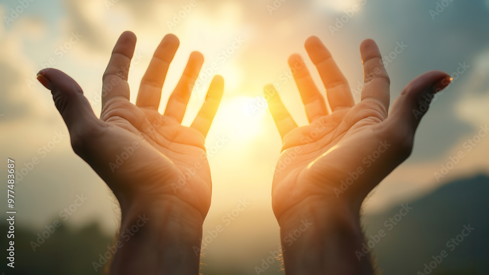 Two hands stretch out towards the bright sun, with the warm sunlight ...