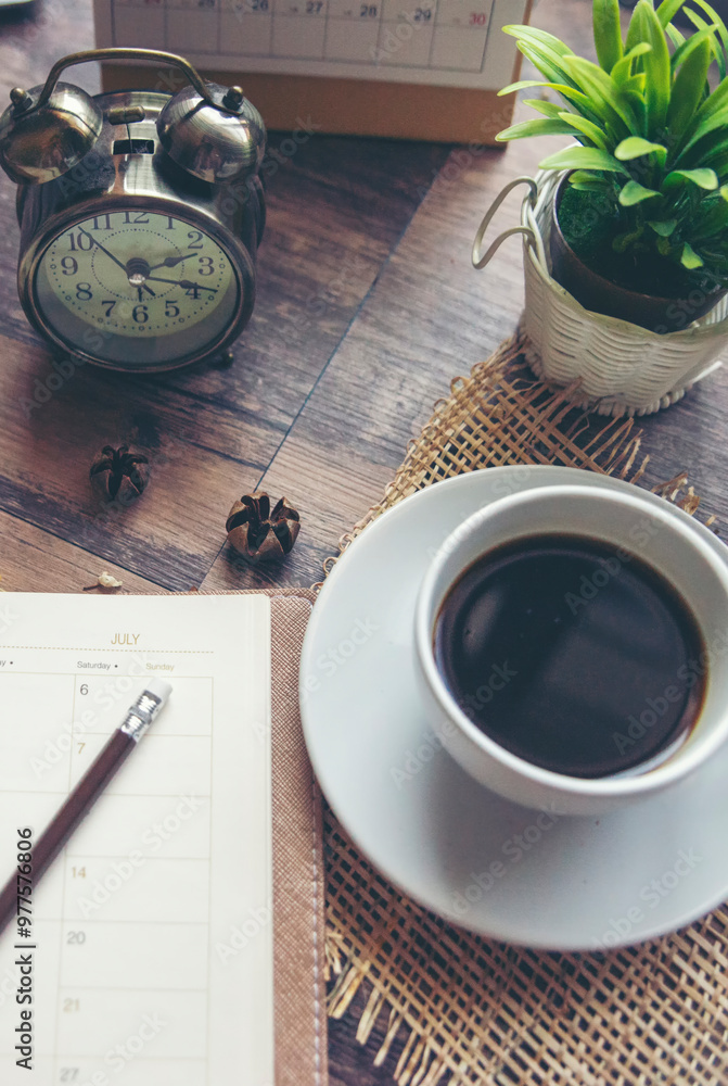 Agenda, planner book, calendar, pencil, and cup of coffee place on ...