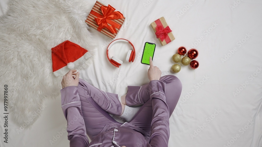 Top view of female sits on the bed using gadget chroma key green screen ...