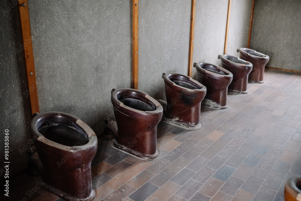 Munich, Germany - September 13, 2024 - A row of simple, worn toilets ...
