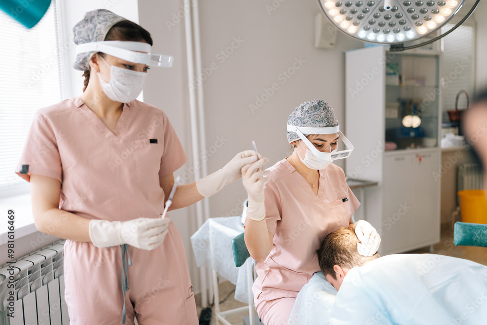 Trichologist performing local anesthesia to back of head in recipient ...