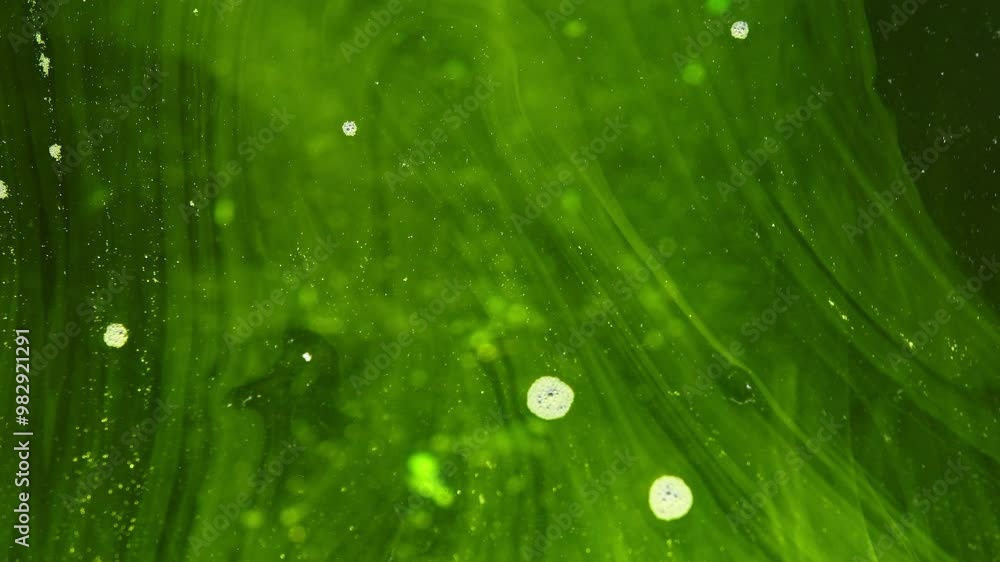 Abstract water background with green glow. Bubbles and dust particles ...