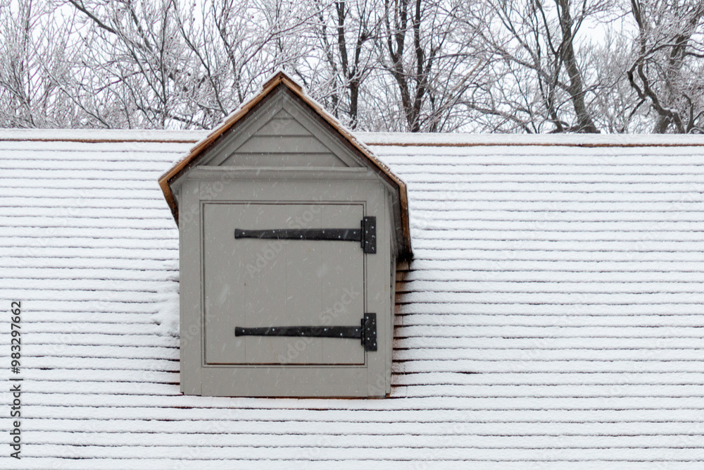 A tan colored vintage building with a pitched roof, a steep slope ...