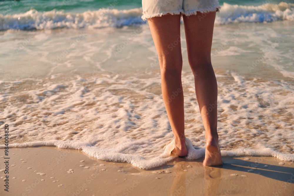 Barefoot on the beach. Low angle woman walking barefoot. A cropped view ...