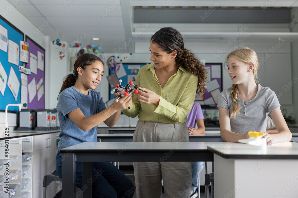 Female science teacher showing a molecular model to girl pupils Stock ...