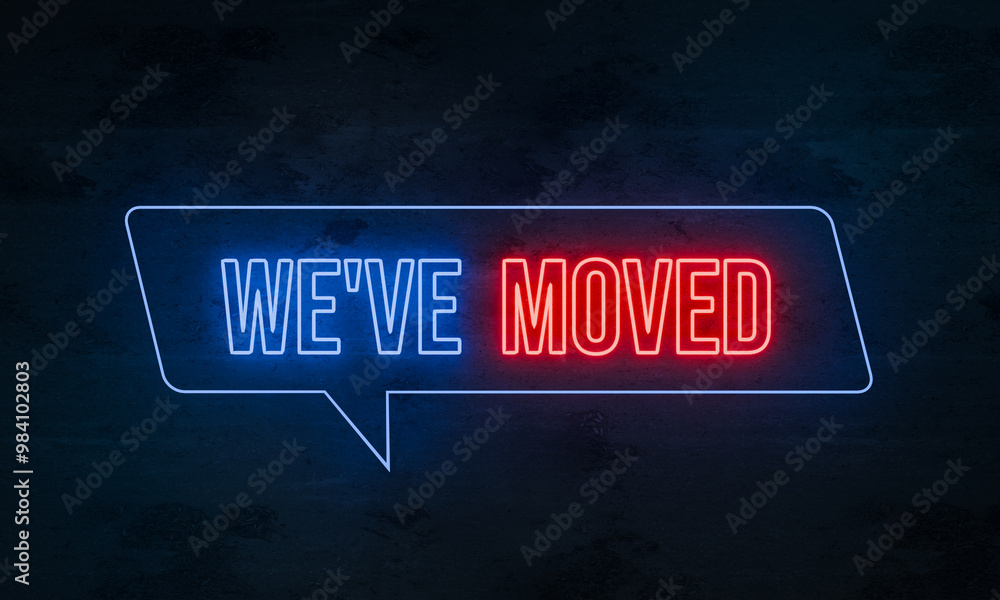 We have moved. Illuminated neon sign in blue and red on a dark concrete ...