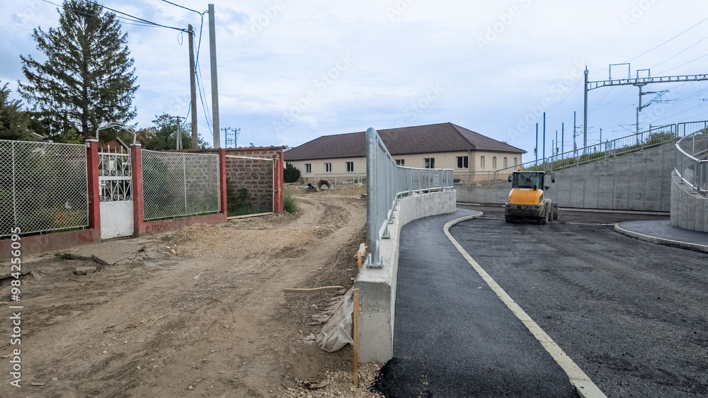 Road construction site near residential area, showcasing an ...
