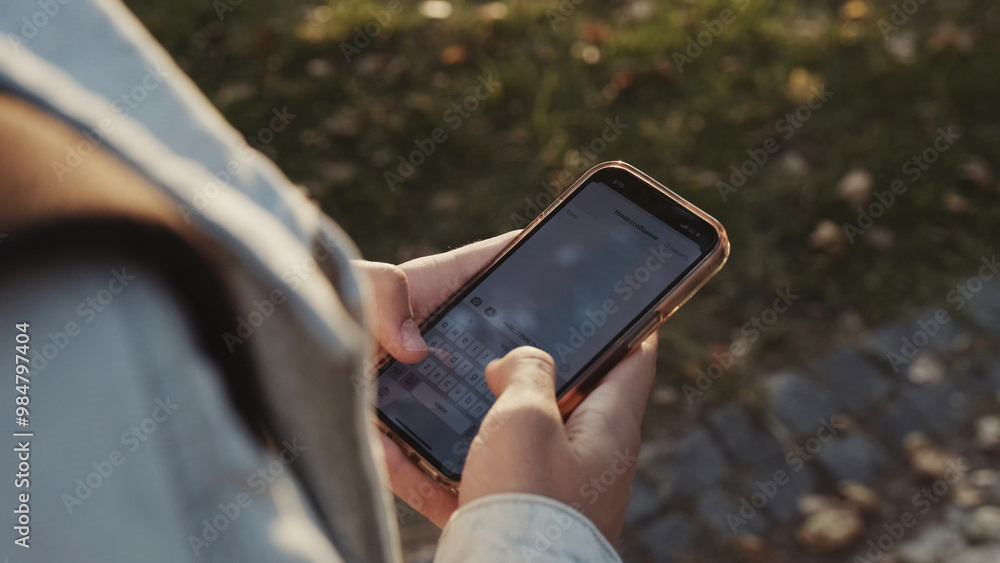Person in the park is typing a text message. Human in the park typing a ...