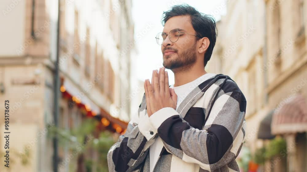 Religious Indian man tourist praying with closed eyes to God asking for ...