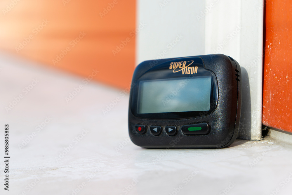 Four-line pager Super Visor on the wall background. Retro messenger ...