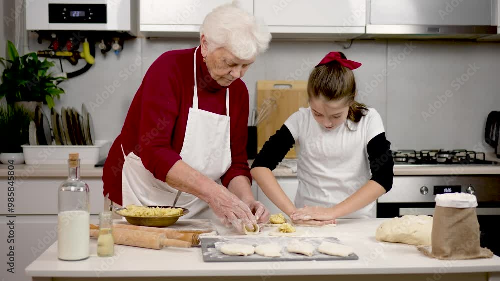 Baking, teaching and learning. Grandmother and little girl having fun ...