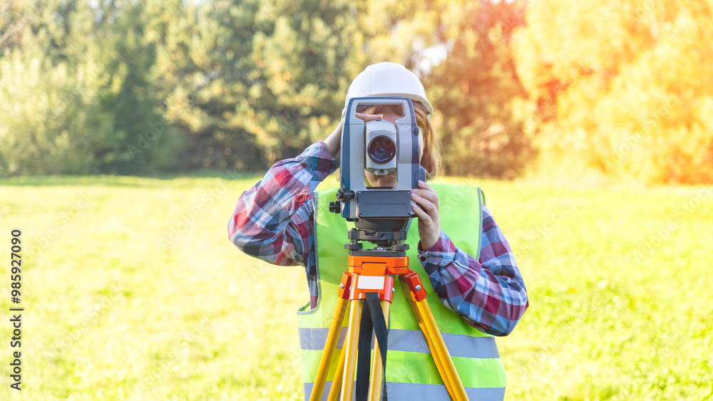 Woman engineer surveyor topographer performs measurements when drawing ...