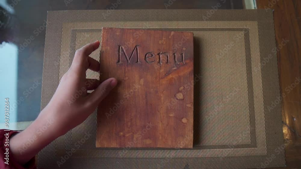 Top down shot of hands of an Indian man placing menu card on the table ...
