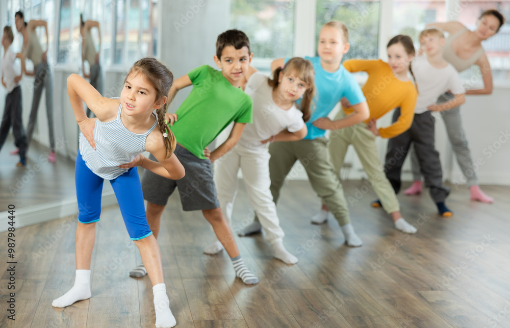 Children perform bends, stretches and squats to prepare their muscles ...
