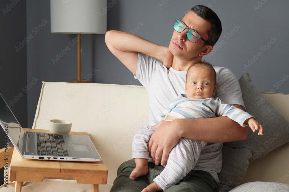 Tired dad sitting on couch feeling pain in neck while working remotely ...