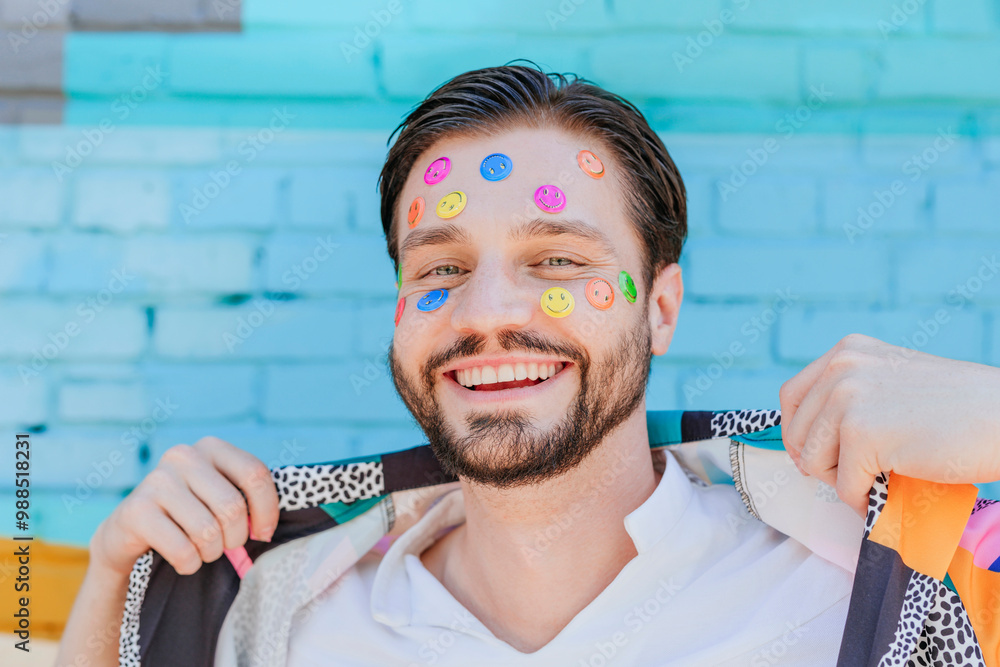 Cheerful man with stickers on face holding collar in front of brick ...