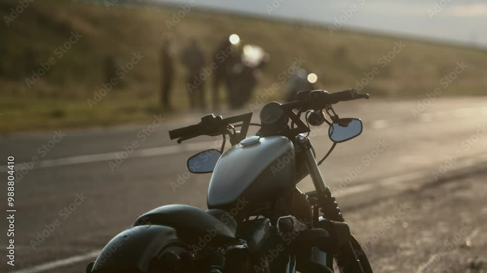 Close-up of black motorcycle standing on side of highway. Blurred ...