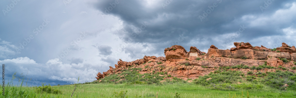 stormy clouds over sandstone cliff and green prairie in Colorado ...