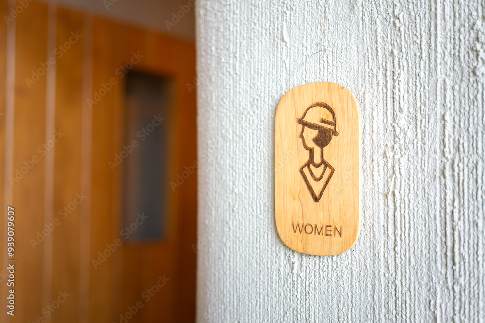 Women or lady sign that made from wooden plate on roughly cement wall ...