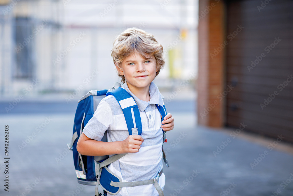 Happy little kid boy with satchel. Schoolkid on the way to school ...