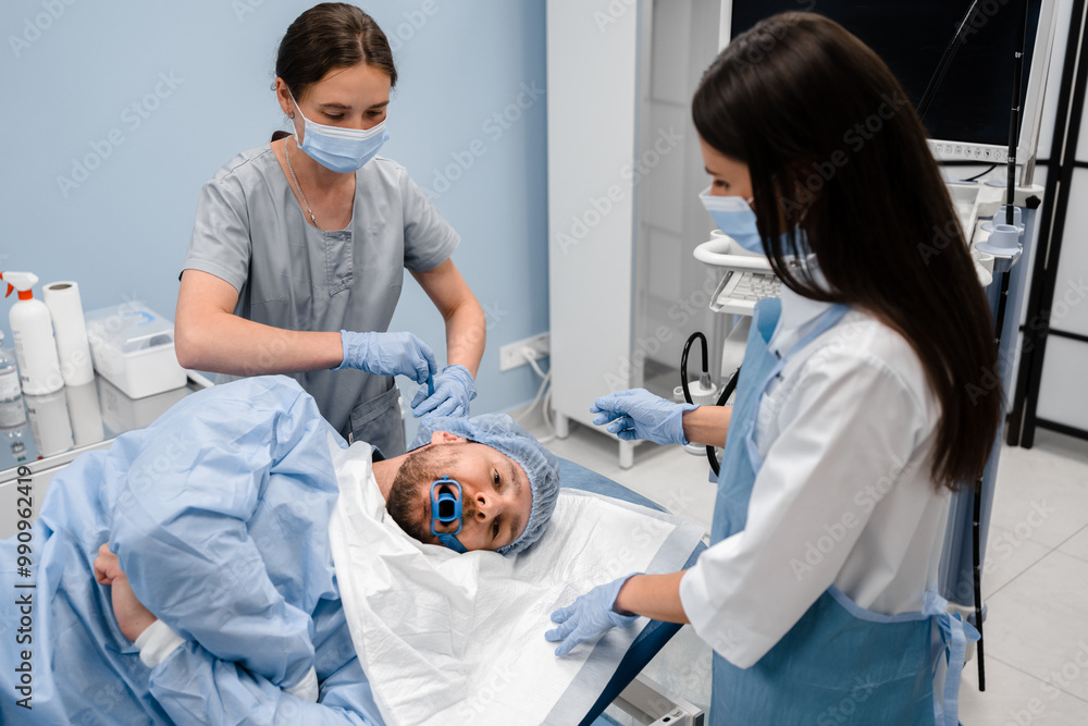 Female doctor and nurse holding endoscope while making gastroscopy ...