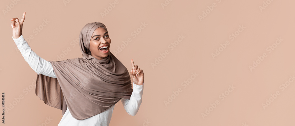 Live With Fun. Joyful black muslim woman in hijab dancing and singing ...