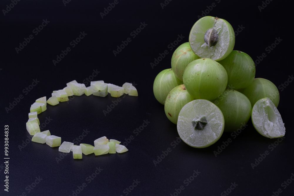 Sliced and whole amla also known as Indian gooseberry placed with ...