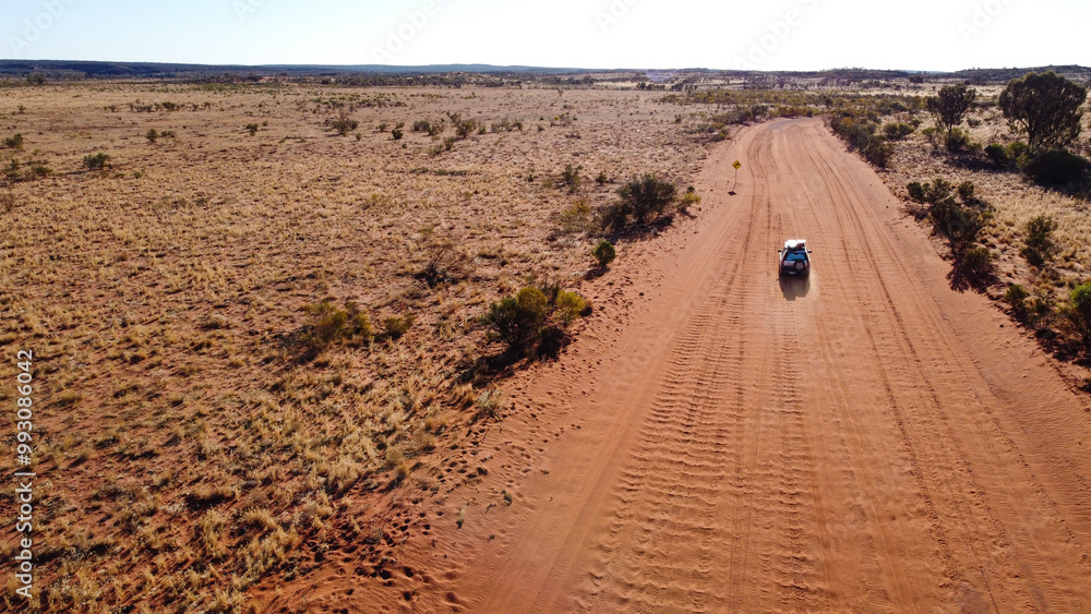Aerial picture of a car driving in the middle of the outback. Long ...