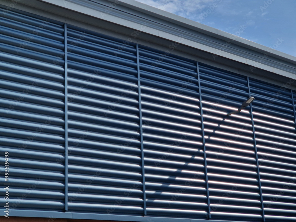 corrugated sheet cladding of the building facade. into the arch shape ...