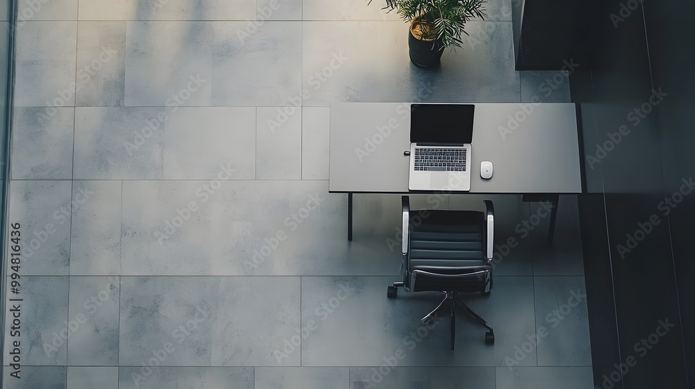 A sleek workspace with a single chair and desk, nothing but a laptop on ...