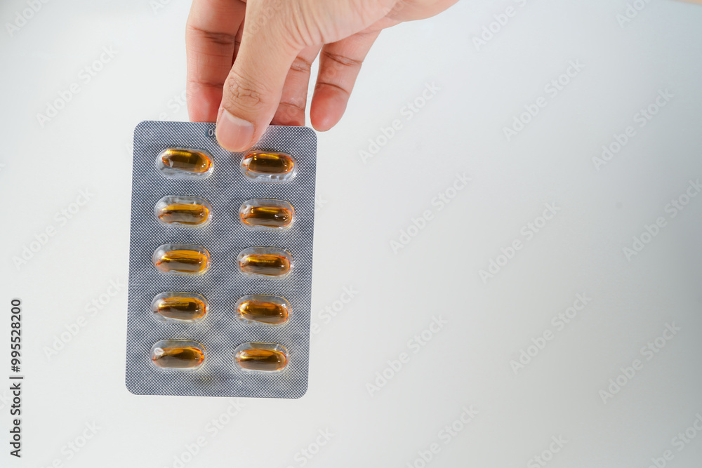 man holding Fish oil blister pack capsules with omega 3, vitamin D ...