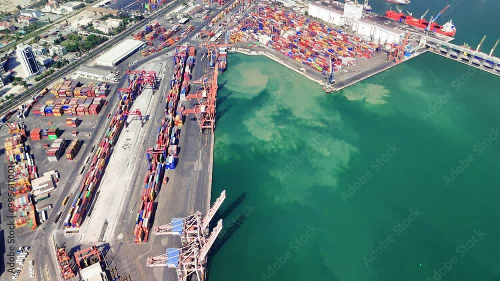 Cranes maneuvering shipping containers at a busy port efficiently load ...