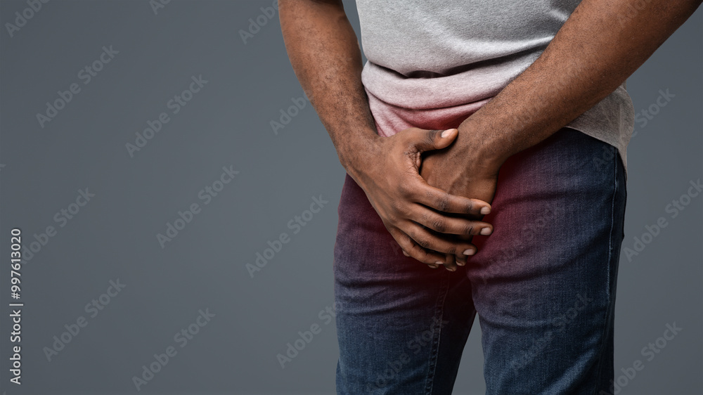 Cropped of black man holding his groin over white background, copy ...
