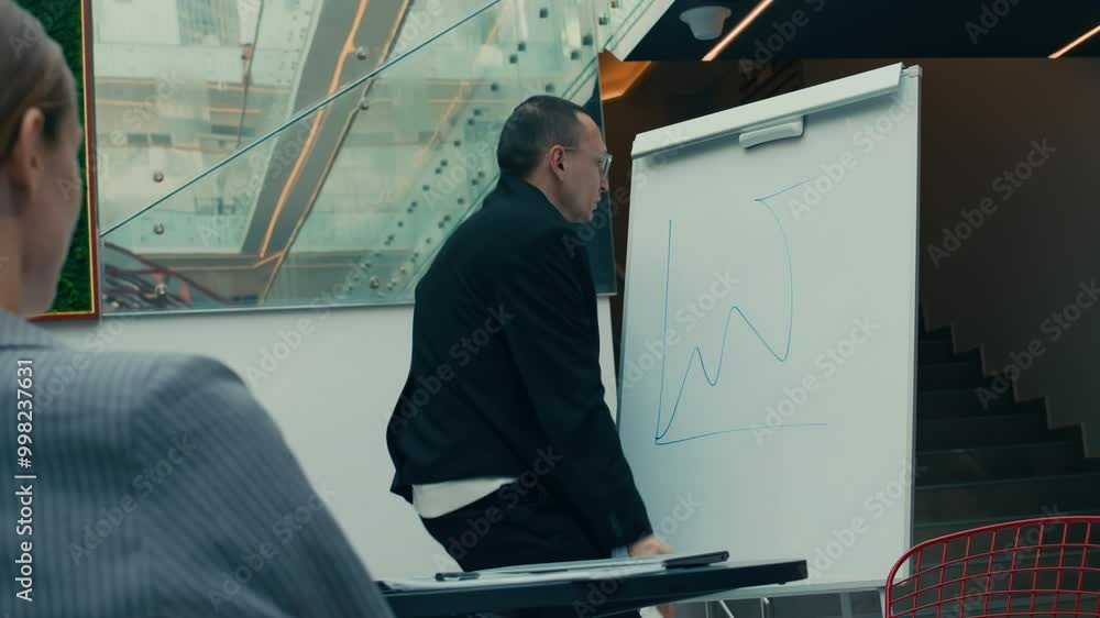 Over shoulder of office employee starting dancing near flipchart in ...