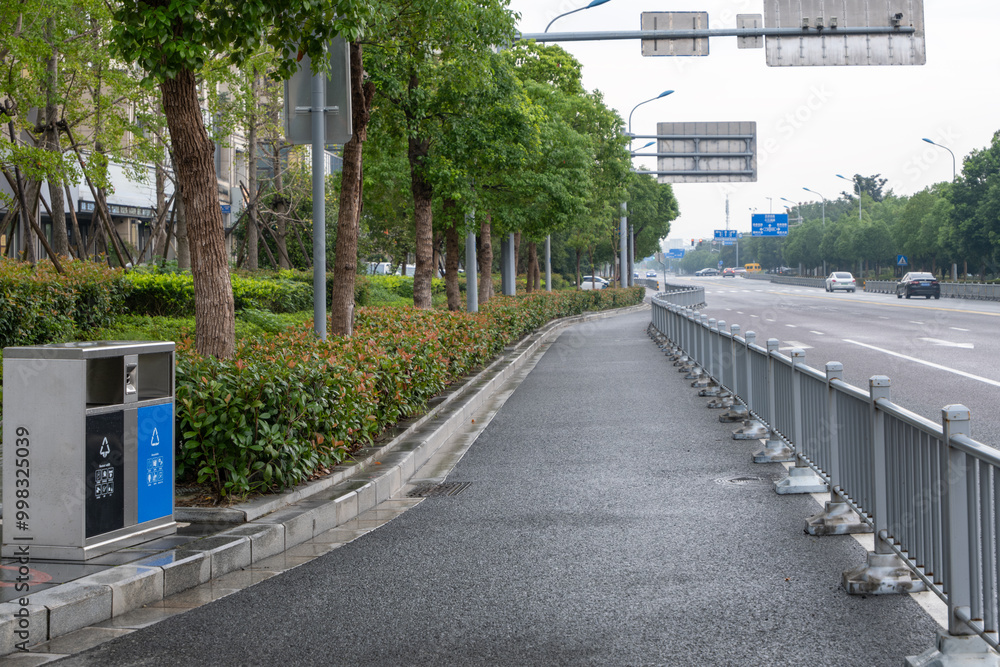 A well-maintained urban street with a bike lane separated by a metal ...