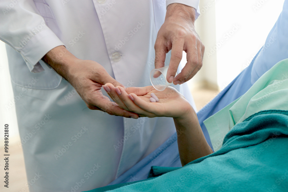 Doctor hand giving medicine to patient who laying in bed at the ...