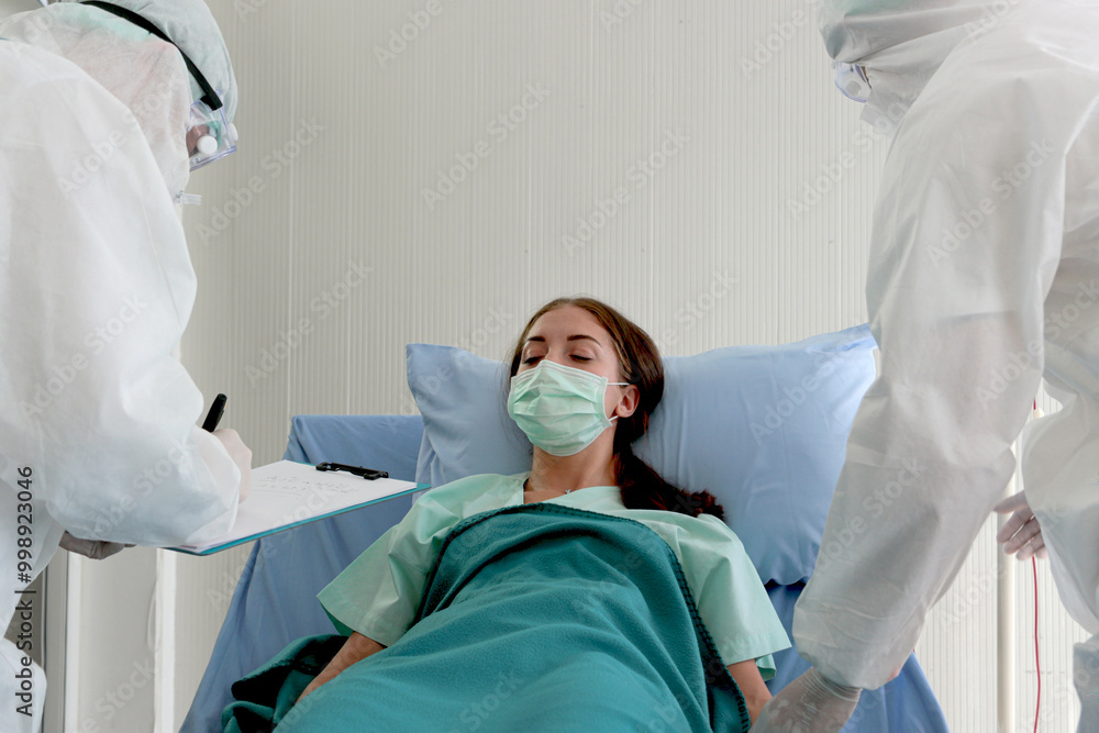 Infected female patient with face mask lying in bed at disease ...