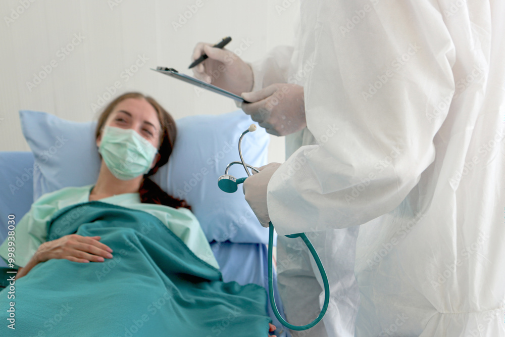 Infected female patient with face mask lying in bed at disease ...