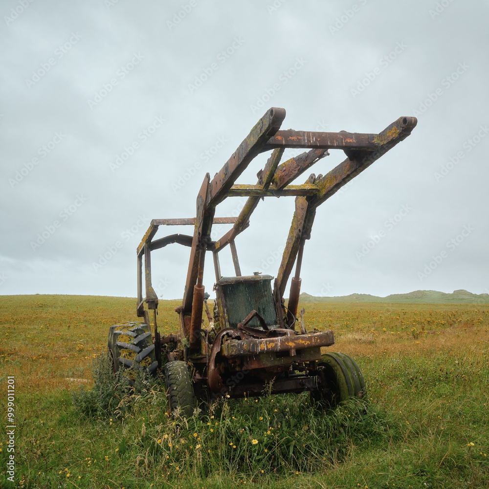 Old style farm tractor sitting on a green grass field. Isle of North ...