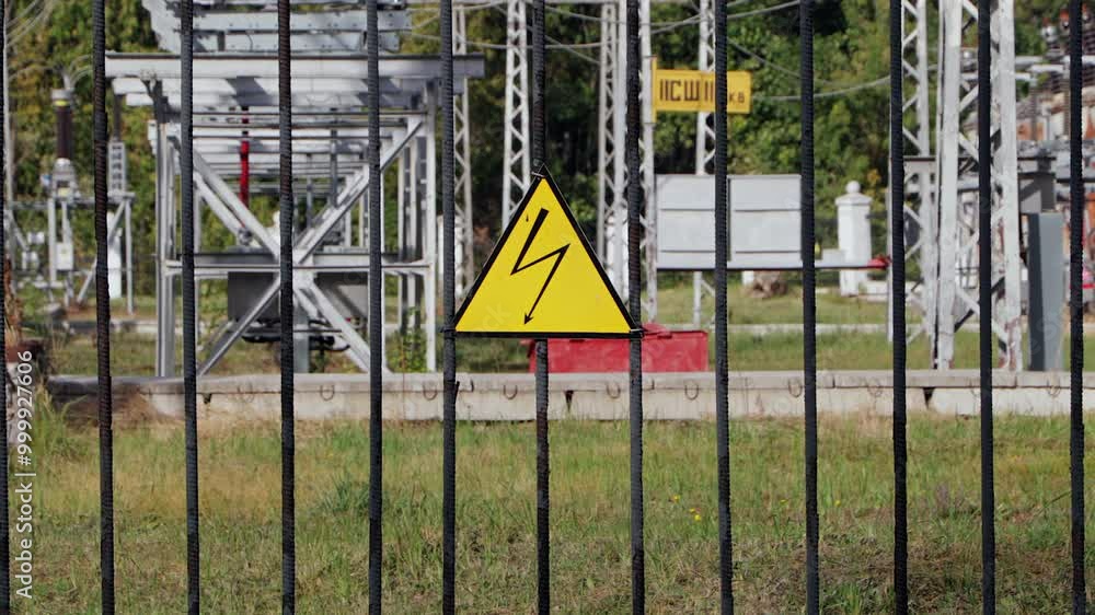 A Yellow High Voltage Warning Sign Displayed On The Fence Of An ...
