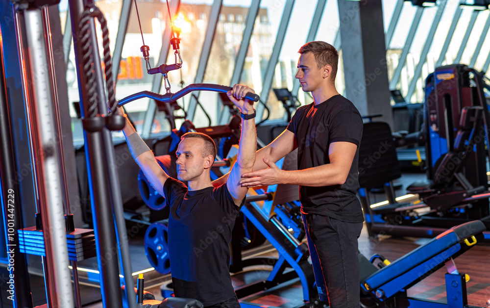 Men training together at a gym during sunset. A personal trainer ...
