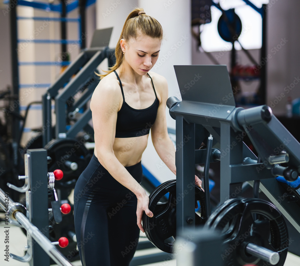 Weightlifting session in a modern gym environment. A focused woman ...