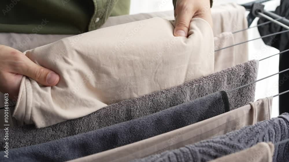 A man hangs out his laundry after washing. Washed clothes on the dryer ...