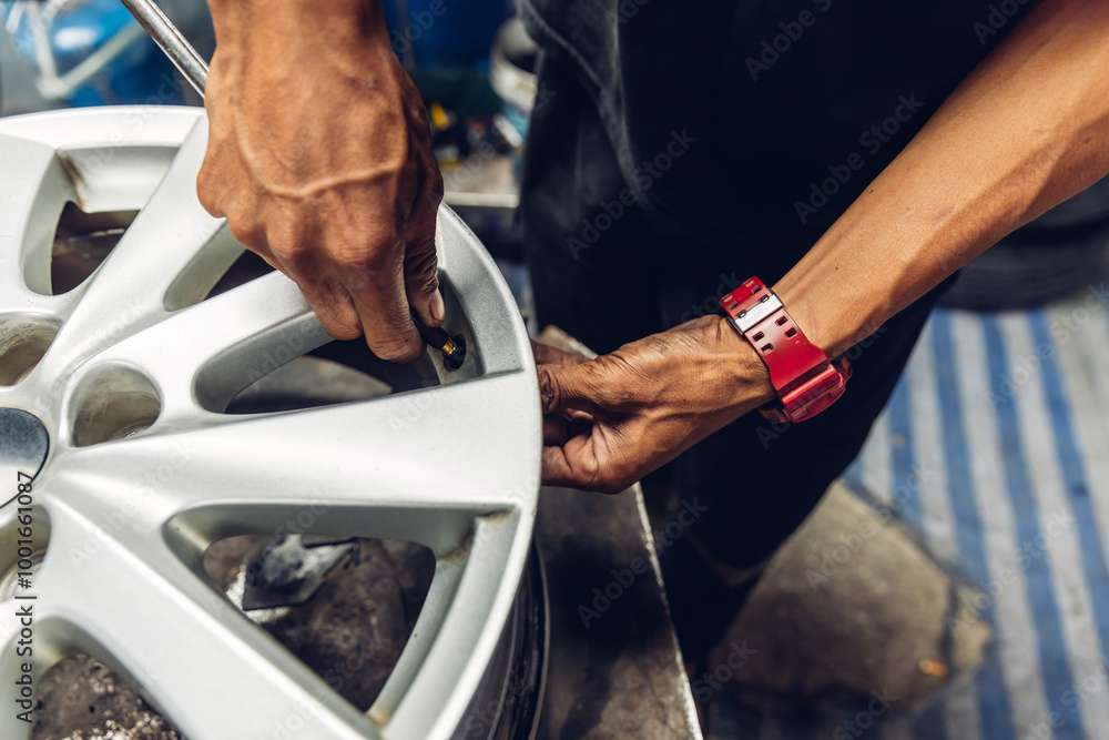 Mechanic removing a tire from the rim after using a tire bead breaker ...