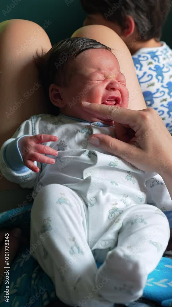 Mother comforting her crying newborn baby in a tender moment, capturing ...