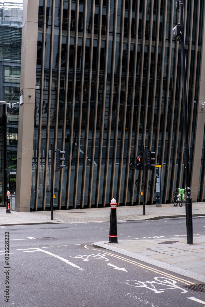 A tall building with vertical lines sits adjacent to traffic lights on ...