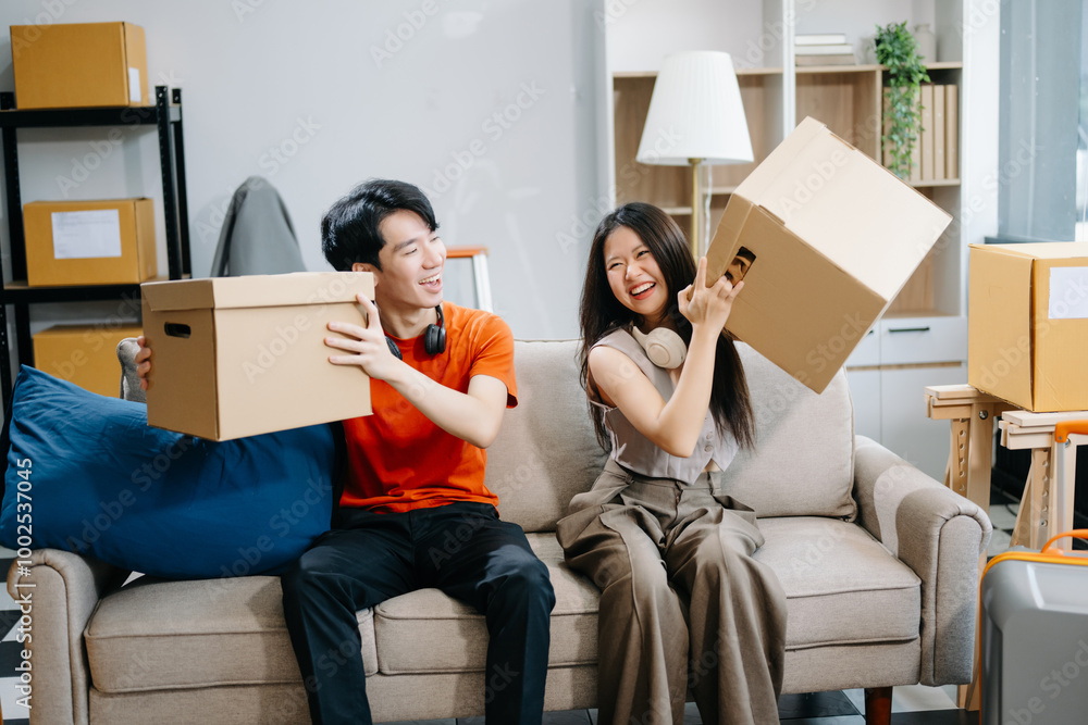 attractive couple man and woman with big boxes moving into a new house, new apartment for couple ...