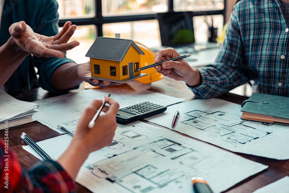 Architects and engineers point to blueprints of architectural drawings ...